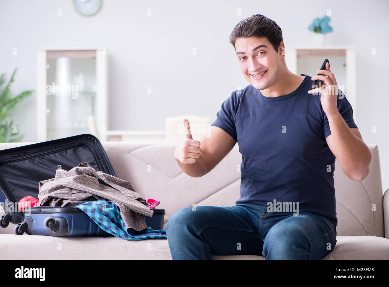 Young man preparing packing for summer vacation Stock Photo - Alamy