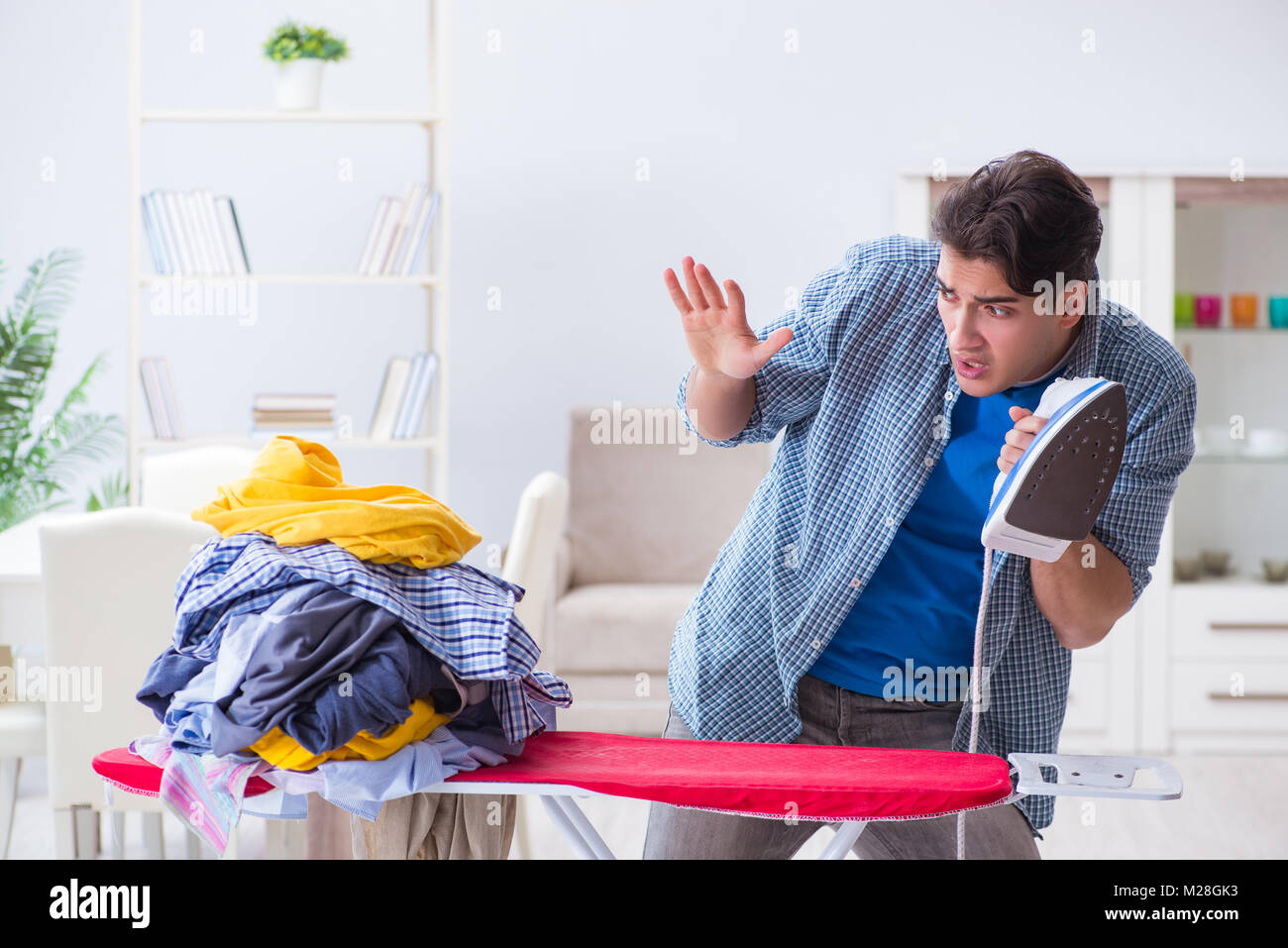 Young man husband doing clothing ironing at home Stock Photo - Alamy