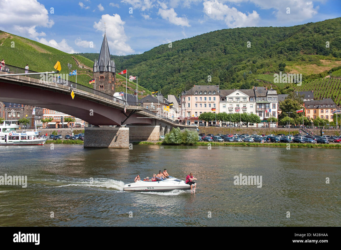 Motorboat with young people passing the Moselle bridge, wine village ...