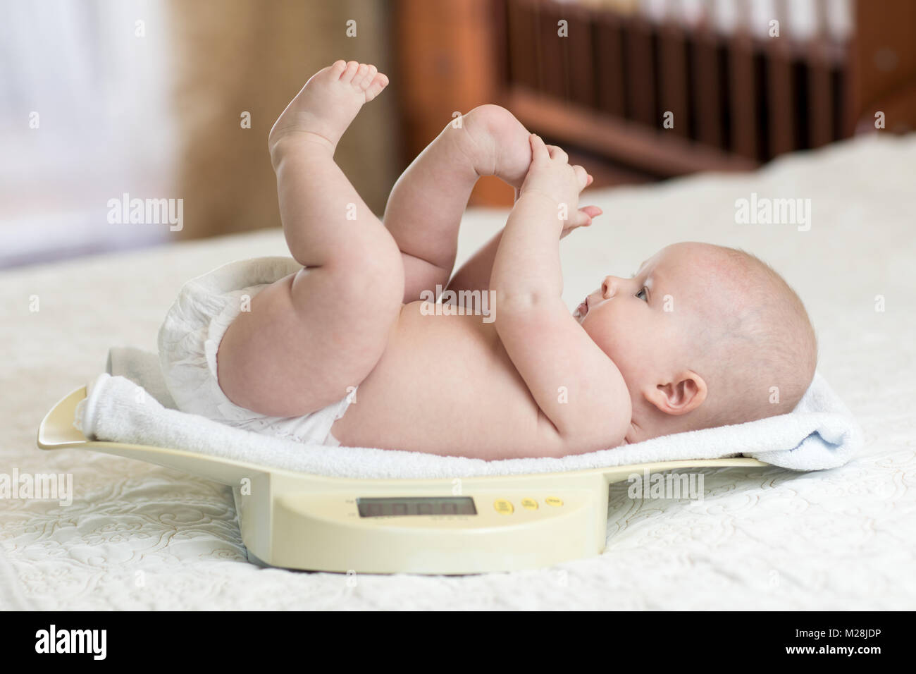 Cute little baby child lying on scales at home Stock Photo - Alamy