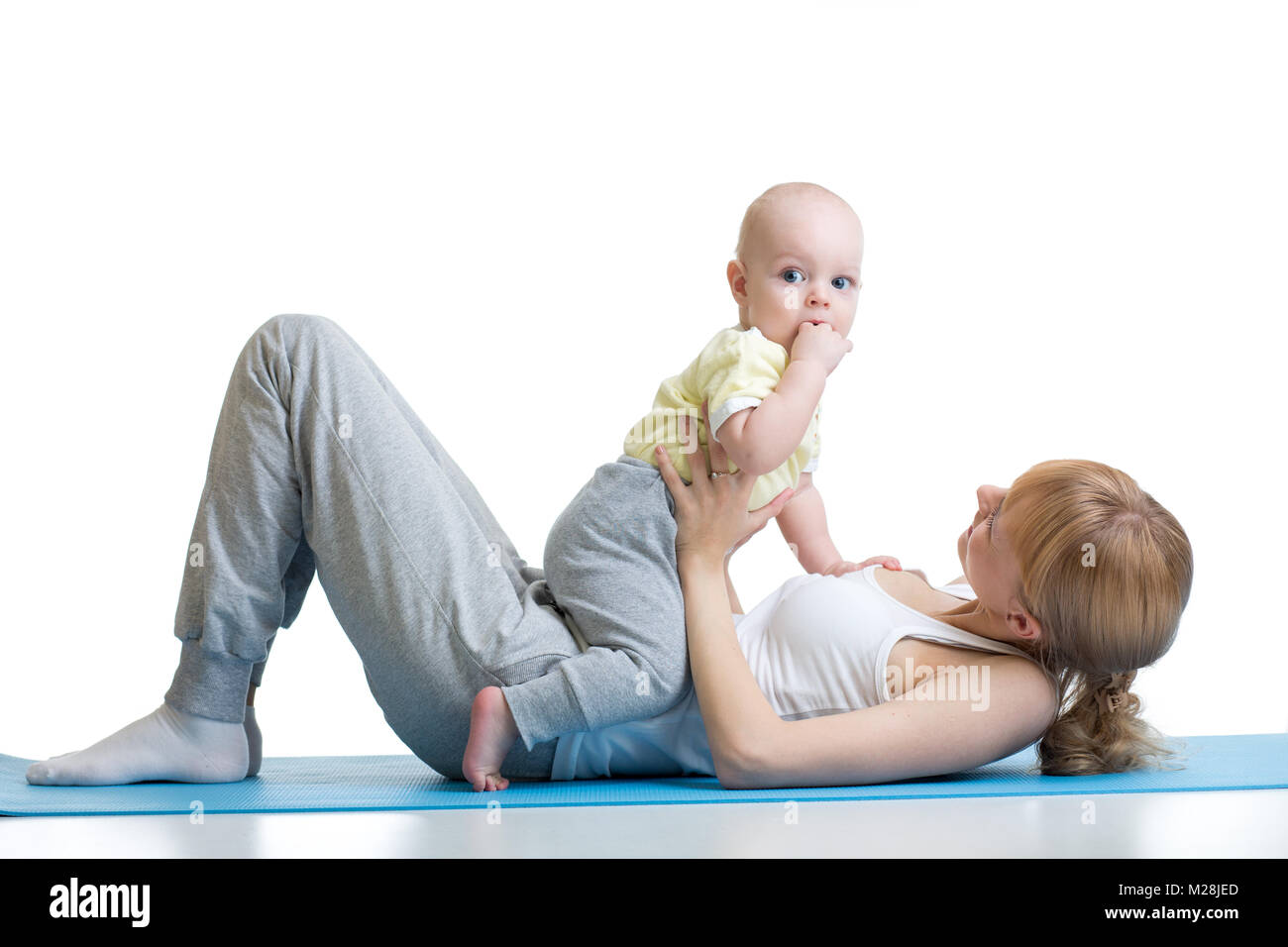 young mother does fitness exercises together with baby boy isolated on ...