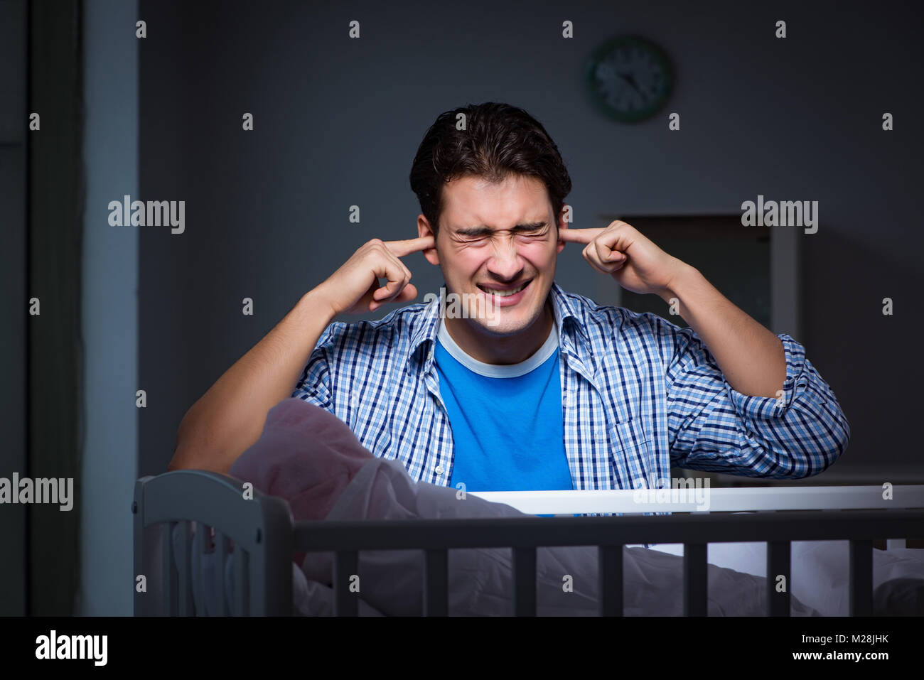 Young father under stress due to baby crying at night Stock Photo - Alamy