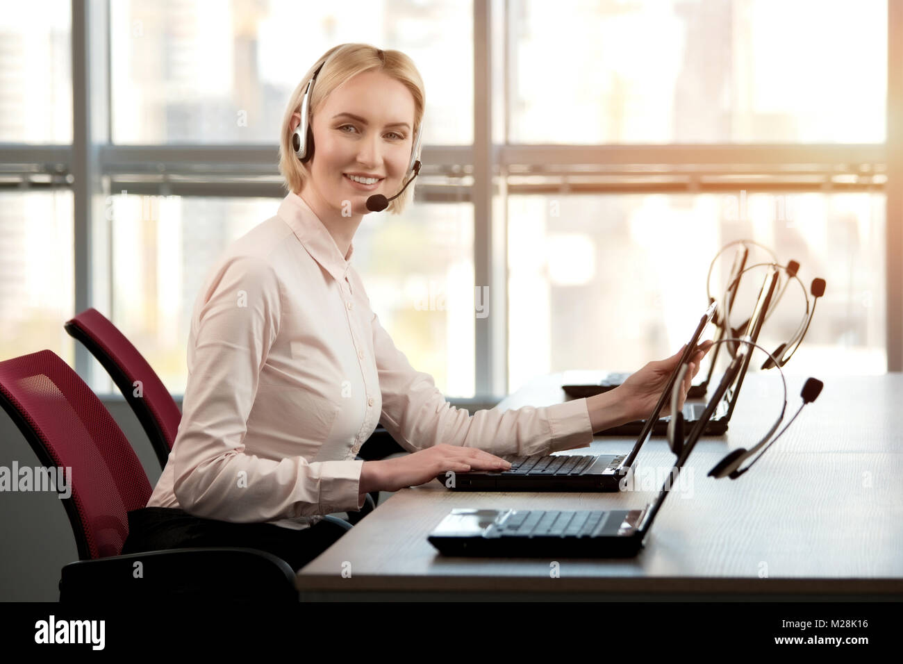 Female operator with headset smiling. Adult female secretary with ...