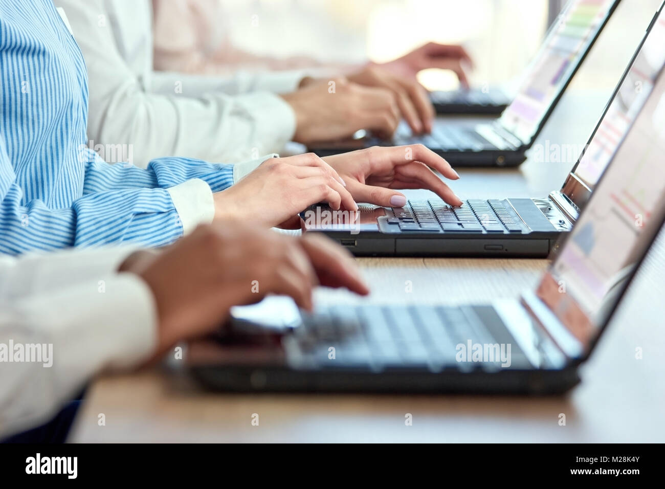 Female hands typing on laptop. Line of office workers hands typing on ...