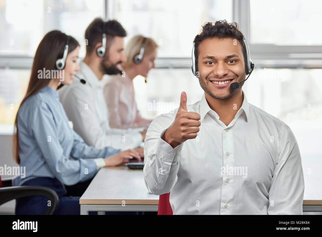 Cheerful american black operator with thumb up. Portrait of young male ...