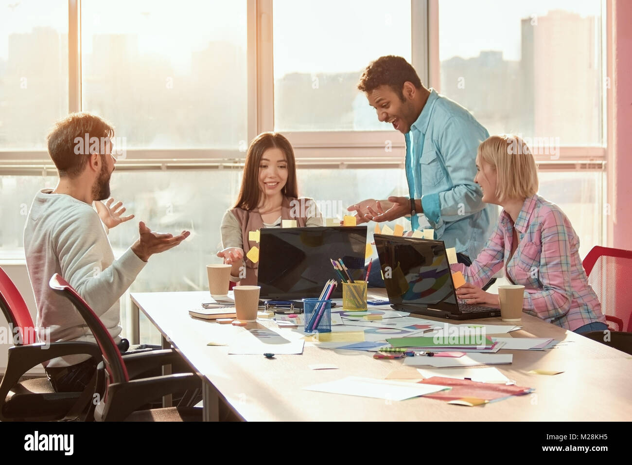 Group of creative designers brainstorming and working on a project ...