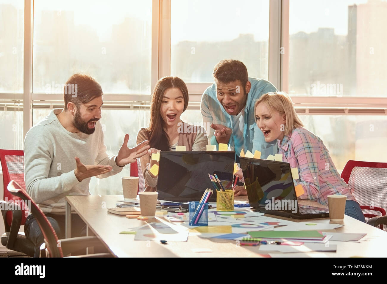 Students having fun and cooperating and working with computer. Four ...