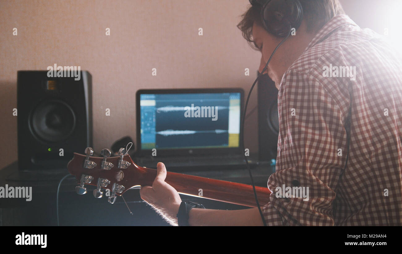 Young musician composes and records music playing the electric guitar ...
