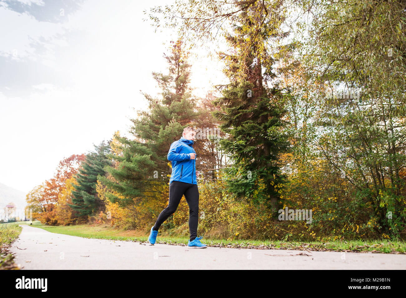 Young athlete running in park in colorful autumn nature Stock Photo - Alamy
