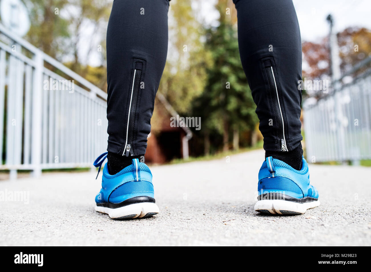 Legs of young runner standing on asphalt path Stock Photo - Alamy