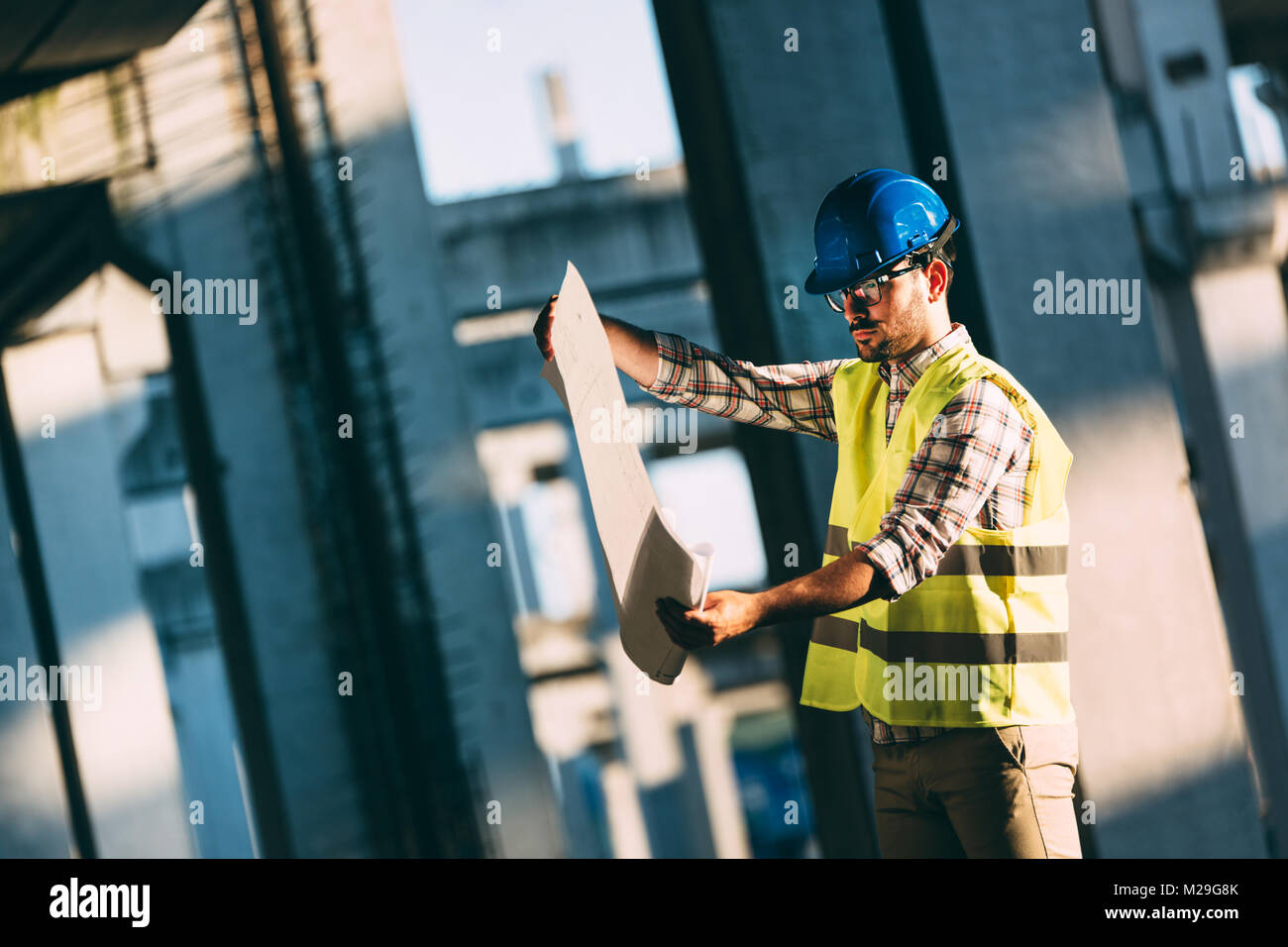 Picture of construction site engineer looking at plan Stock Photo - Alamy