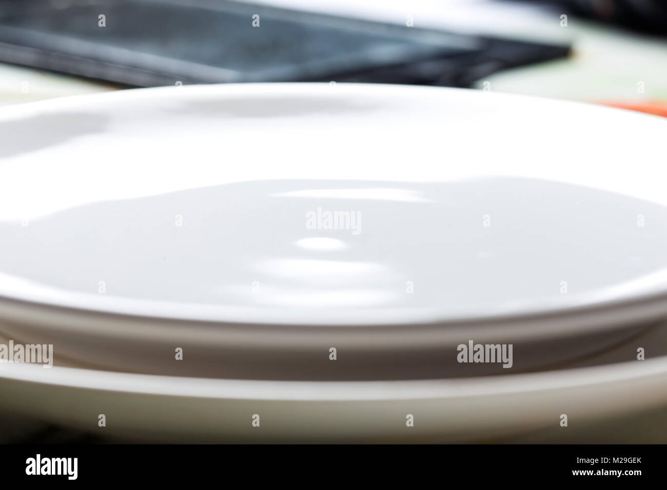 Close up of two white modern round plates. Table setting low angle view ...