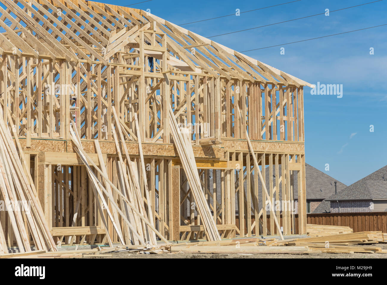 Close-up wood frame house under construction next to completed homes in ...
