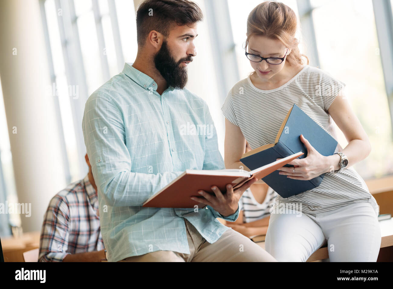 Happy students couple in school library have discussion Stock Photo - Alamy