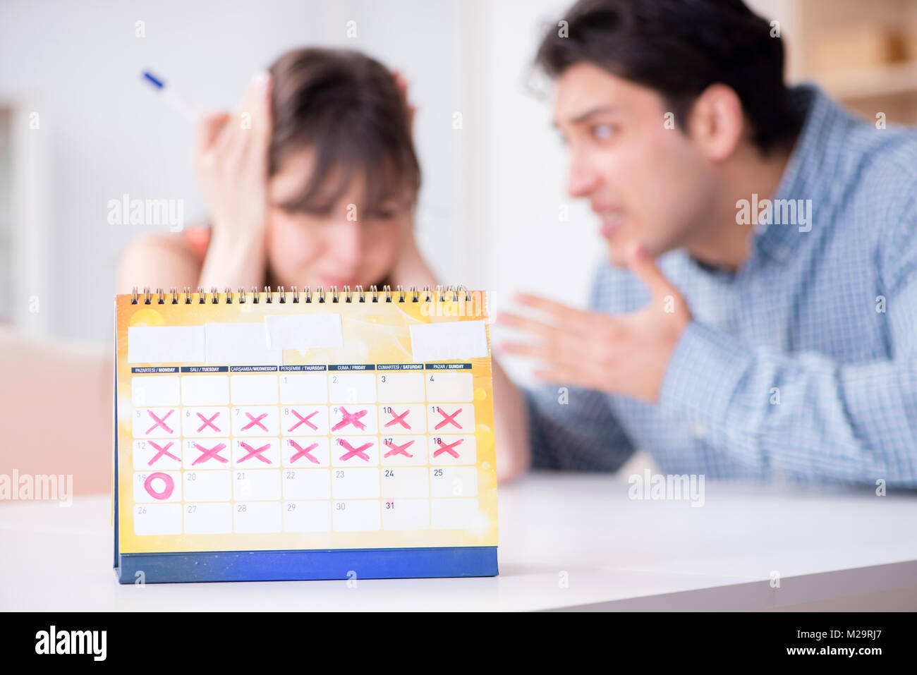 Young family in pregnancy planning concept with ovulation calendar ...