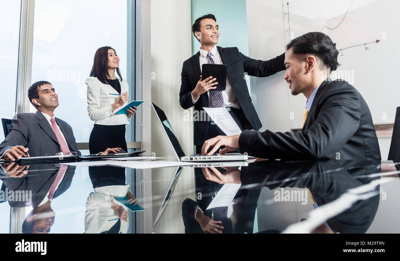 Asian business people in meeting room, listening to presentation and ...
