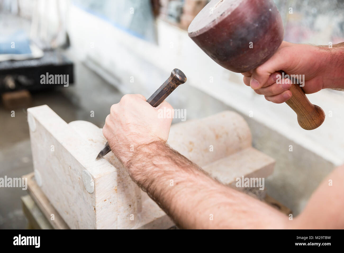 Stone carver working with hammer and chisel at marble column Stock ...