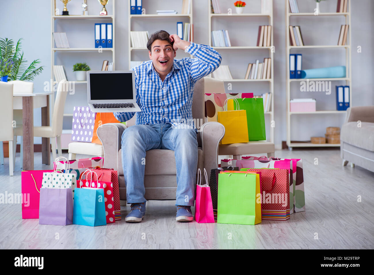 Young man after excessive shopping at home Stock Photo - Alamy