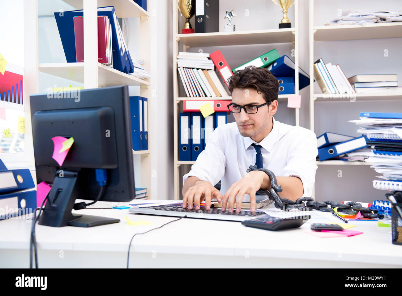 Employee attached and chained to his desk with chain Stock Photo - Alamy