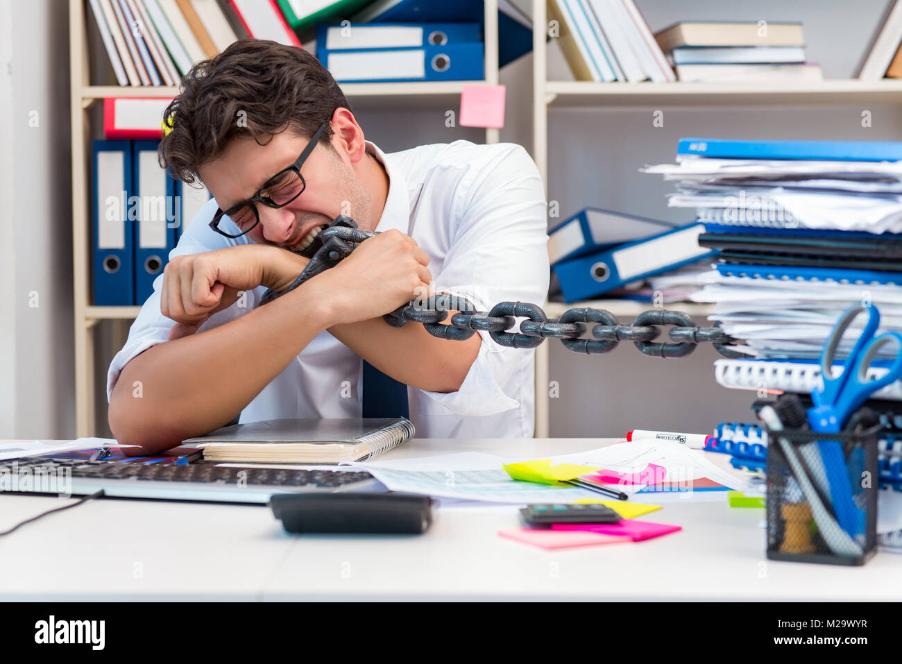 Employee attached and chained to his desk with chain Stock Photo - Alamy