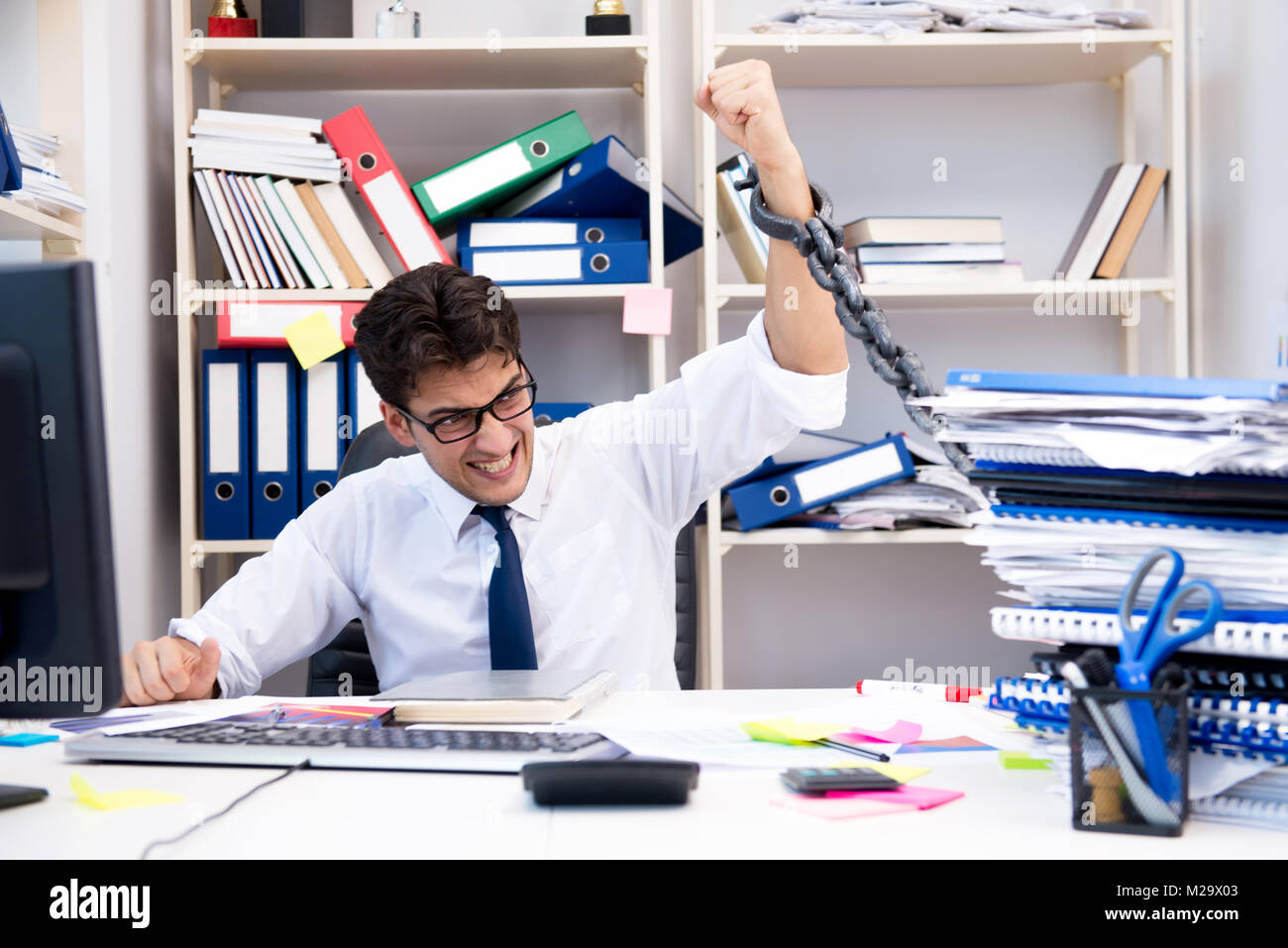 Employee attached and chained to his desk with chain Stock Photo - Alamy