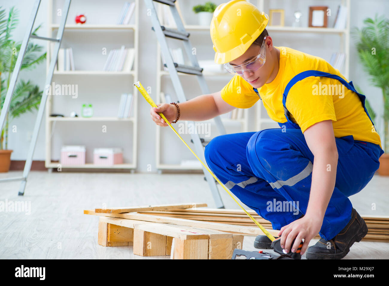Young man assembling wood pallet Stock Photo - Alamy