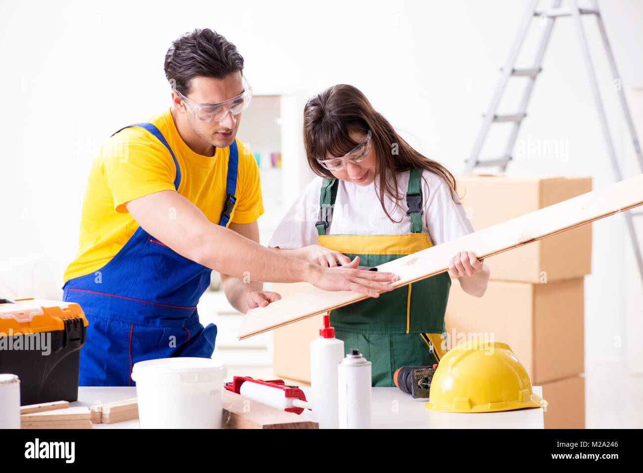 Man explaining woman woodworking tips in wood workshop Stock Photo - Alamy