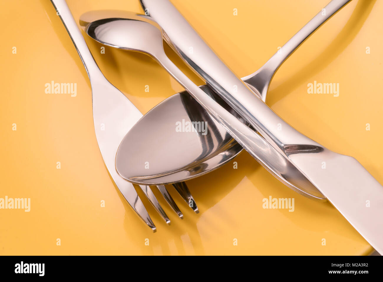 Cutlery on yellow plate close up. Food and restaurant theme still life ...