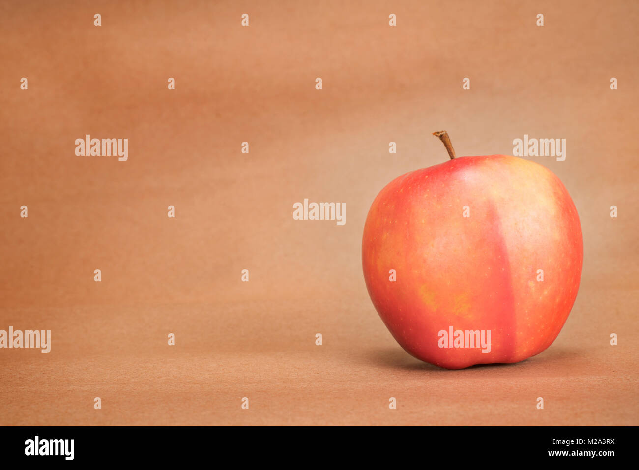 Red apple on craft paper background with copy space Stock Photo - Alamy