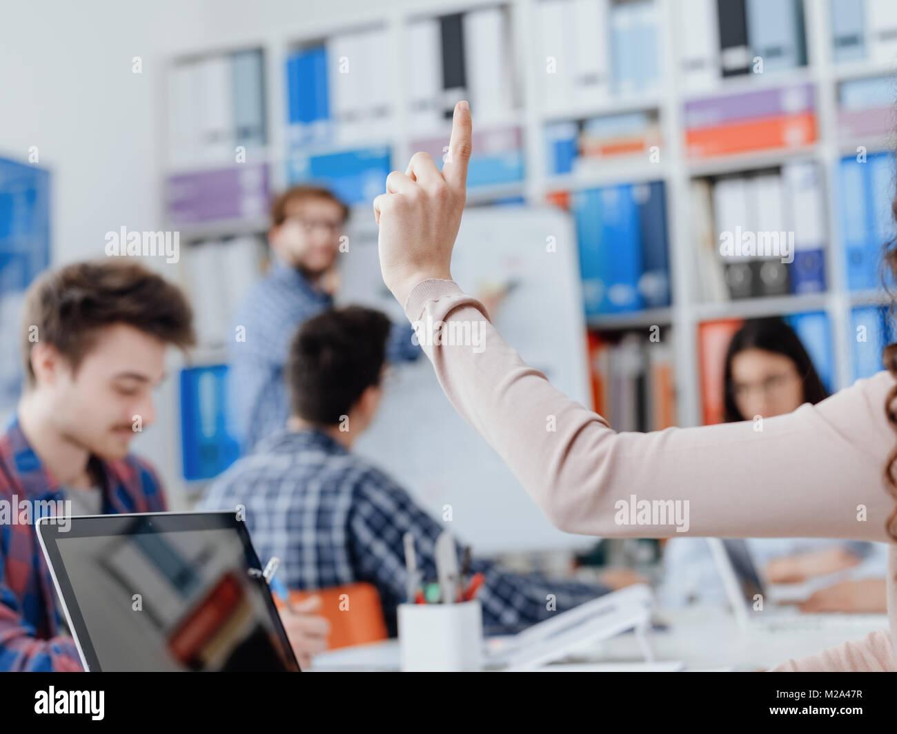 Young business team meeting and discussing a project, a woman is asking ...