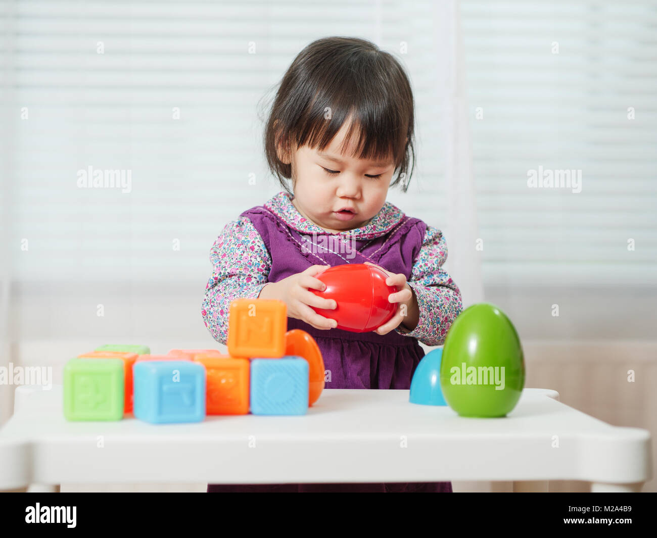 baby girl playing geometry blocks at home Stock Photo - Alamy