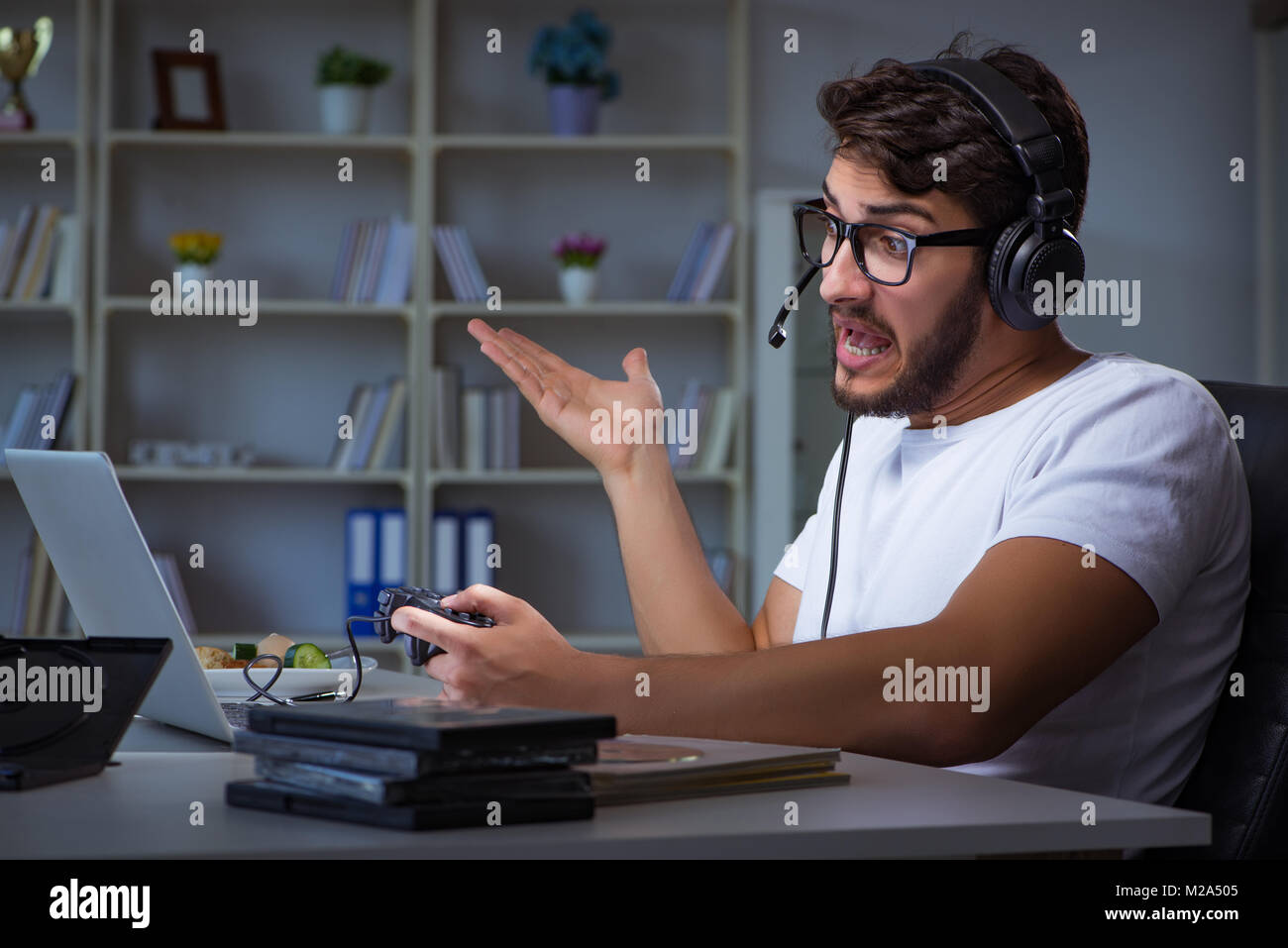 Young man playing games long hours late in the office Stock Photo - Alamy