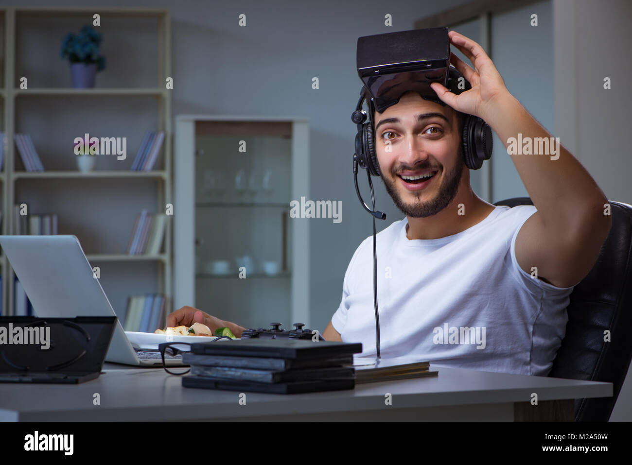 Young man playing games long hours late in the office Stock Photo - Alamy