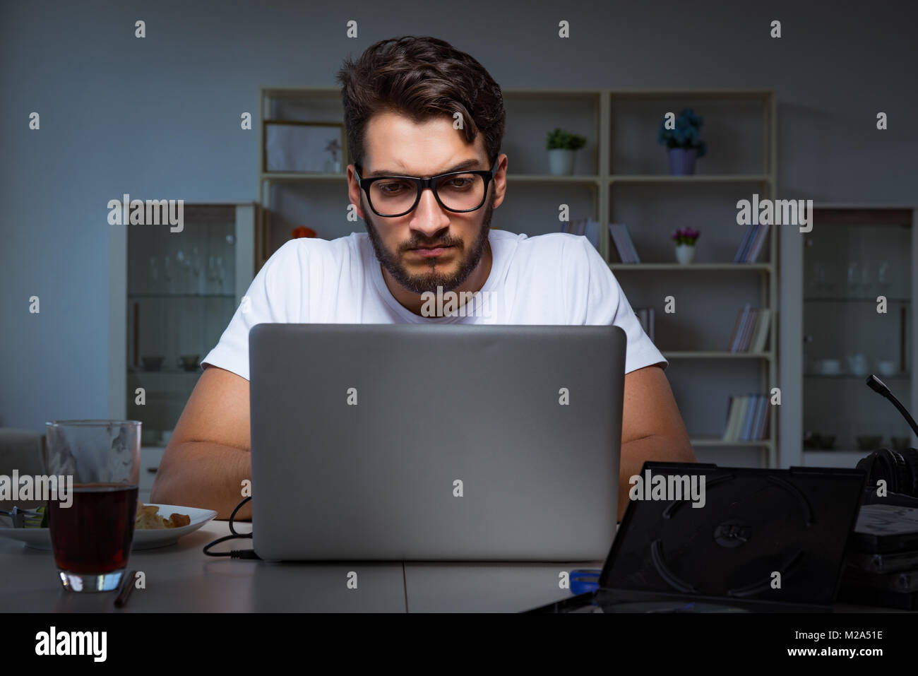 Young man staying late in office to do overtime work Stock Photo - Alamy