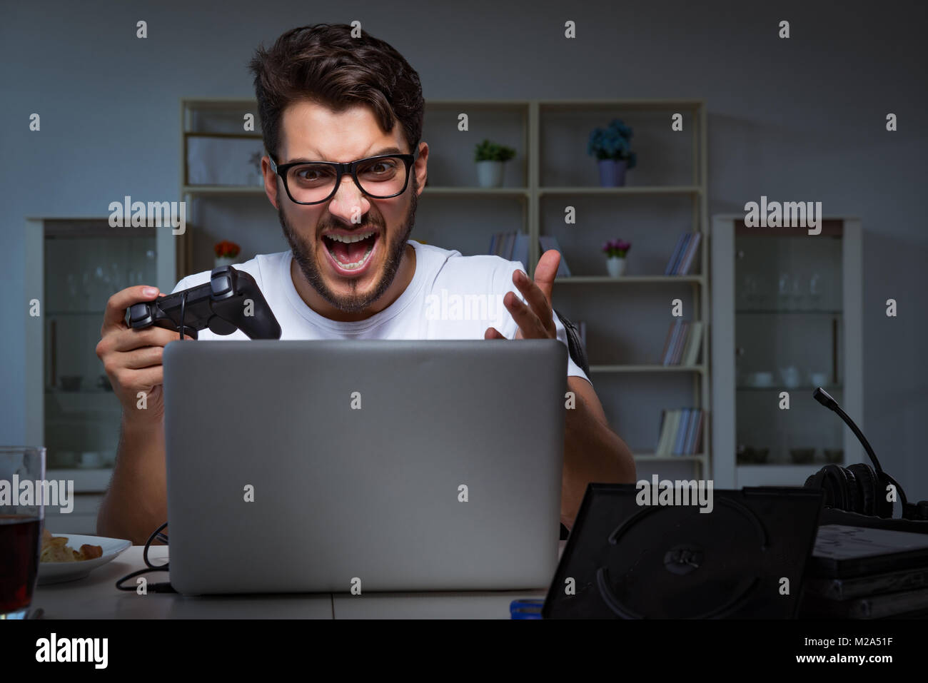 Young man playing games long hours late in the office Stock Photo - Alamy