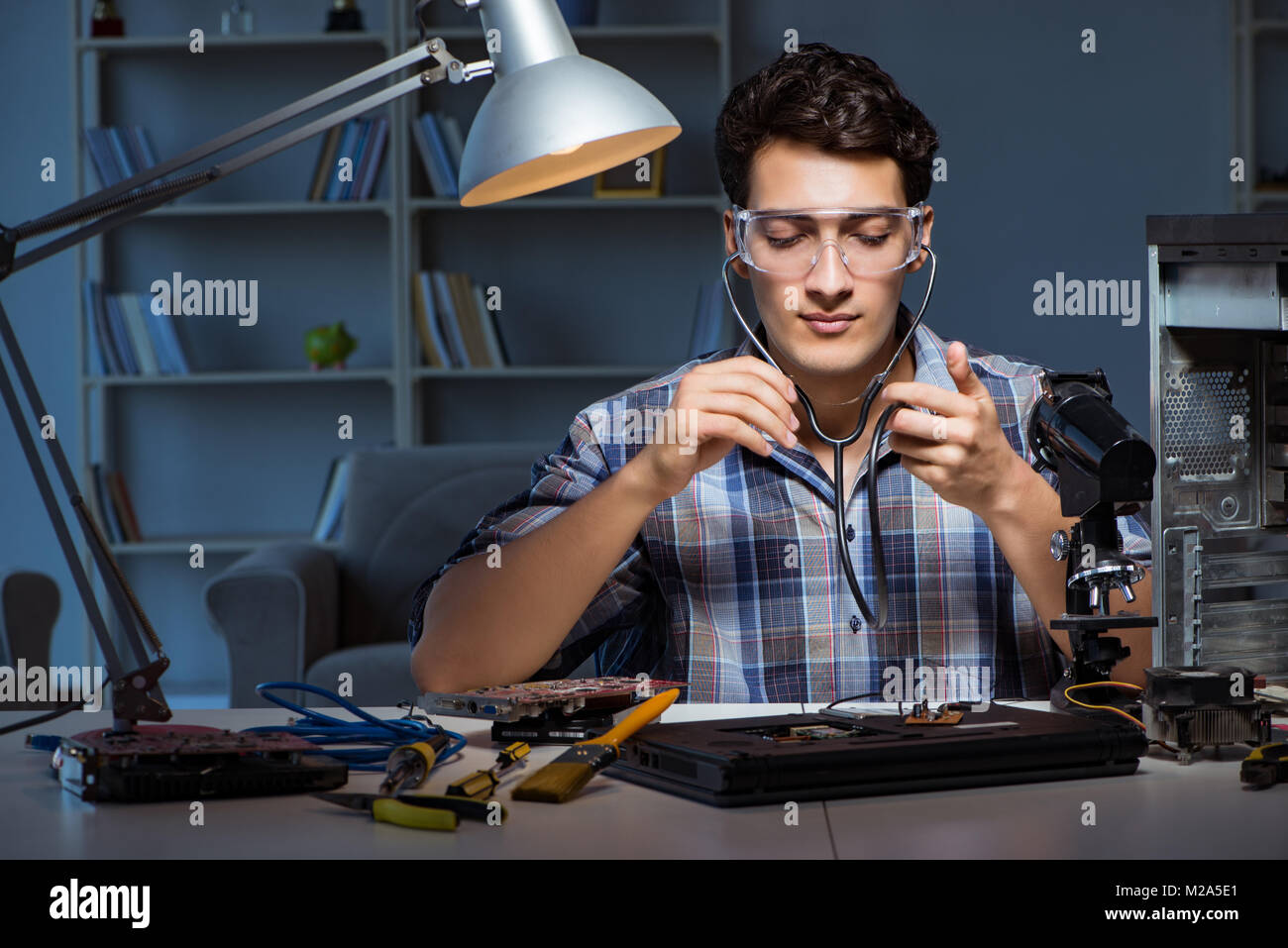 Computer repair concept with man inspecting with stethoscope Stock ...