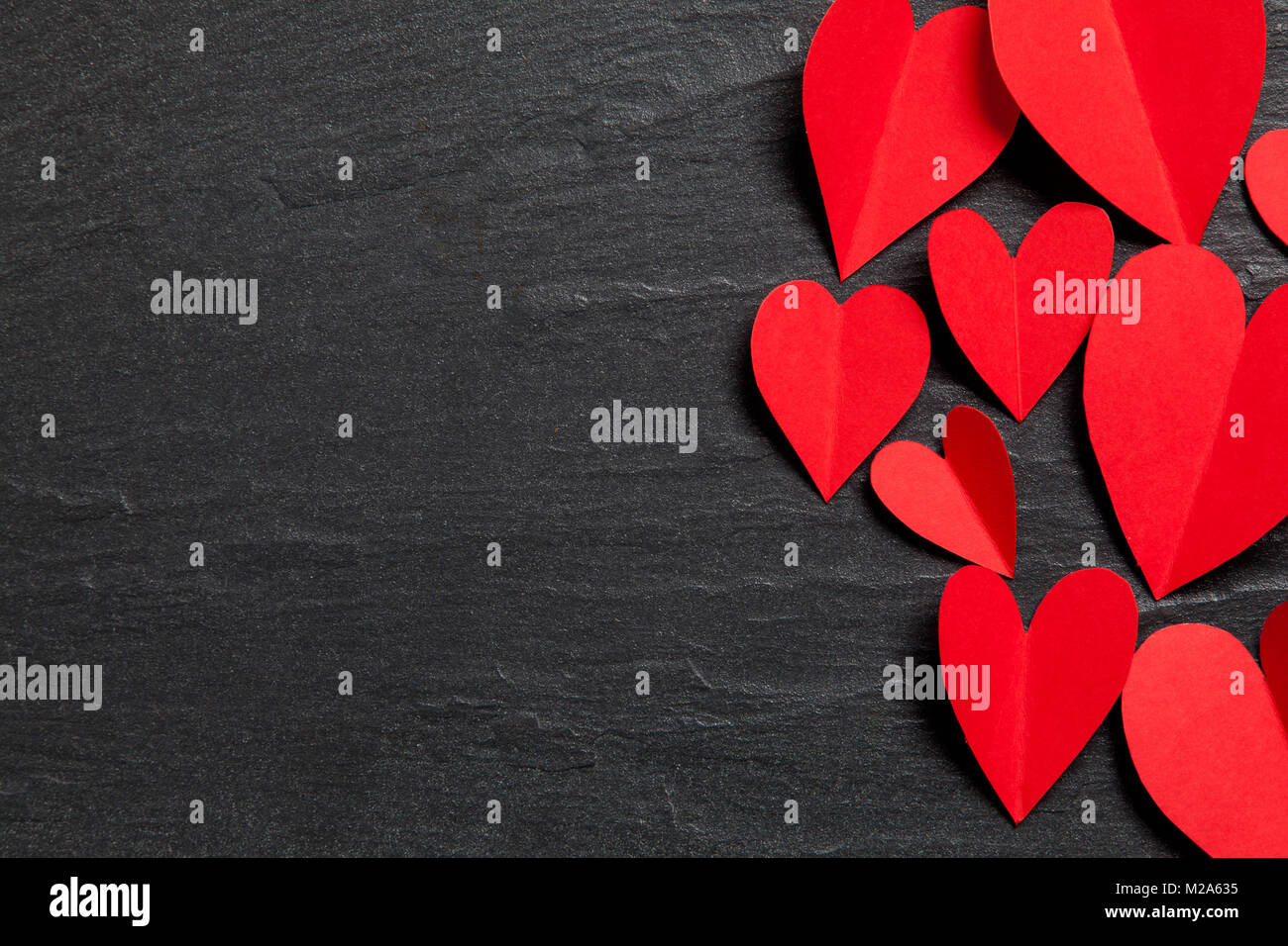 Red handmade paper hearts on a slate background Stock Photo - Alamy