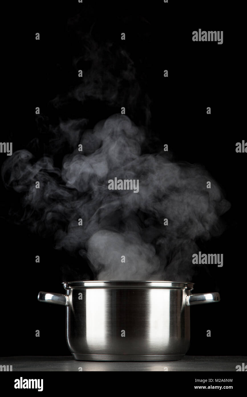 Steaming pot on black background Stock Photo - Alamy