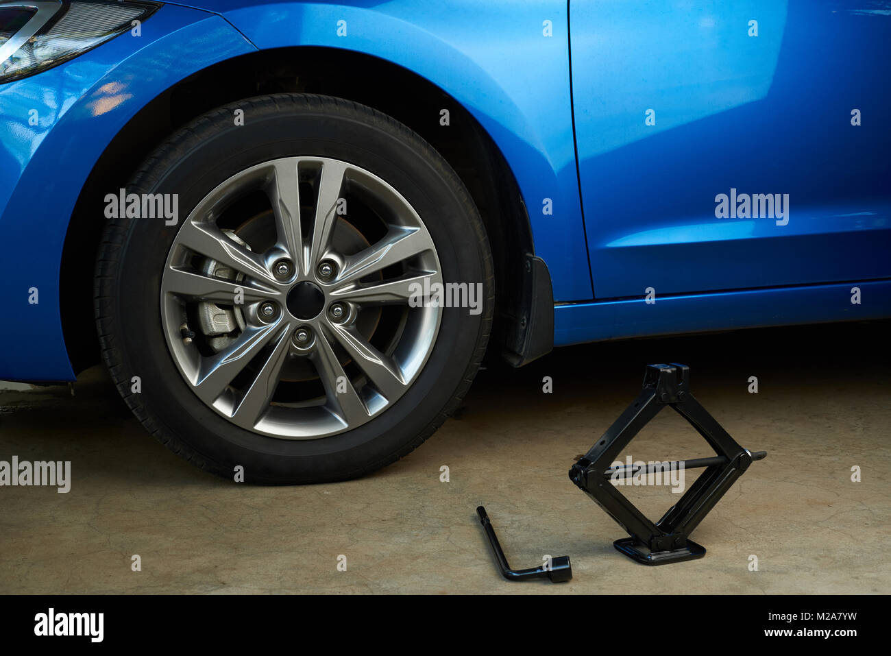Tools for replacing car wheel on modern car background Stock Photo - Alamy
