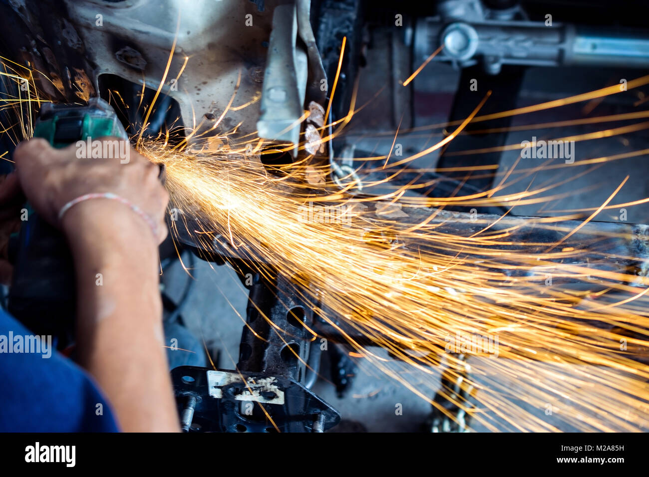Electric wheel grinding on chassis of a car - auto body repair shop ...