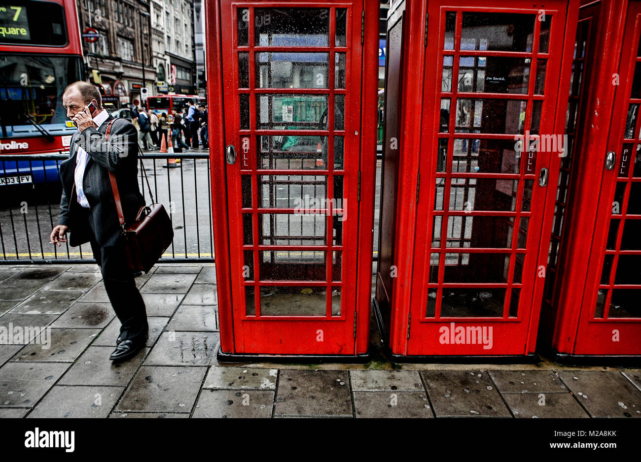 A business man is talking on his cell phone next to a classical London ...
