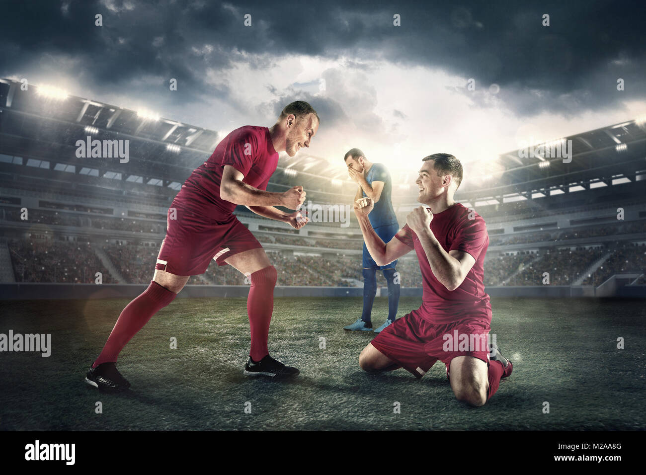 The football players in motion on the field of stadium Stock Photo - Alamy