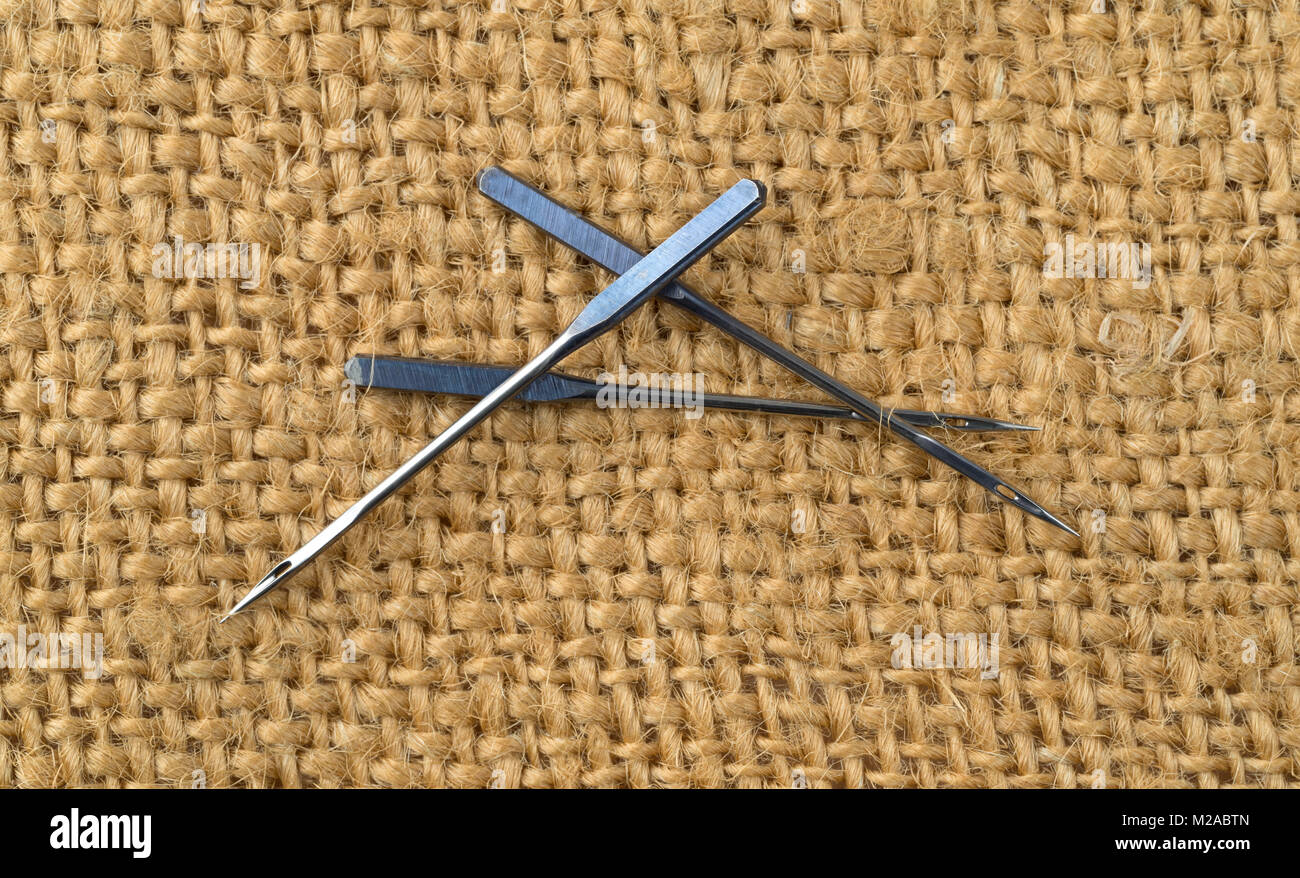Three heavy duty denim sewing machine needles on burlap cloth Stock ...