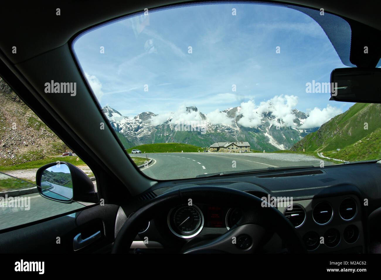 A view on the Alps through the windscreen of the car while driving on ...