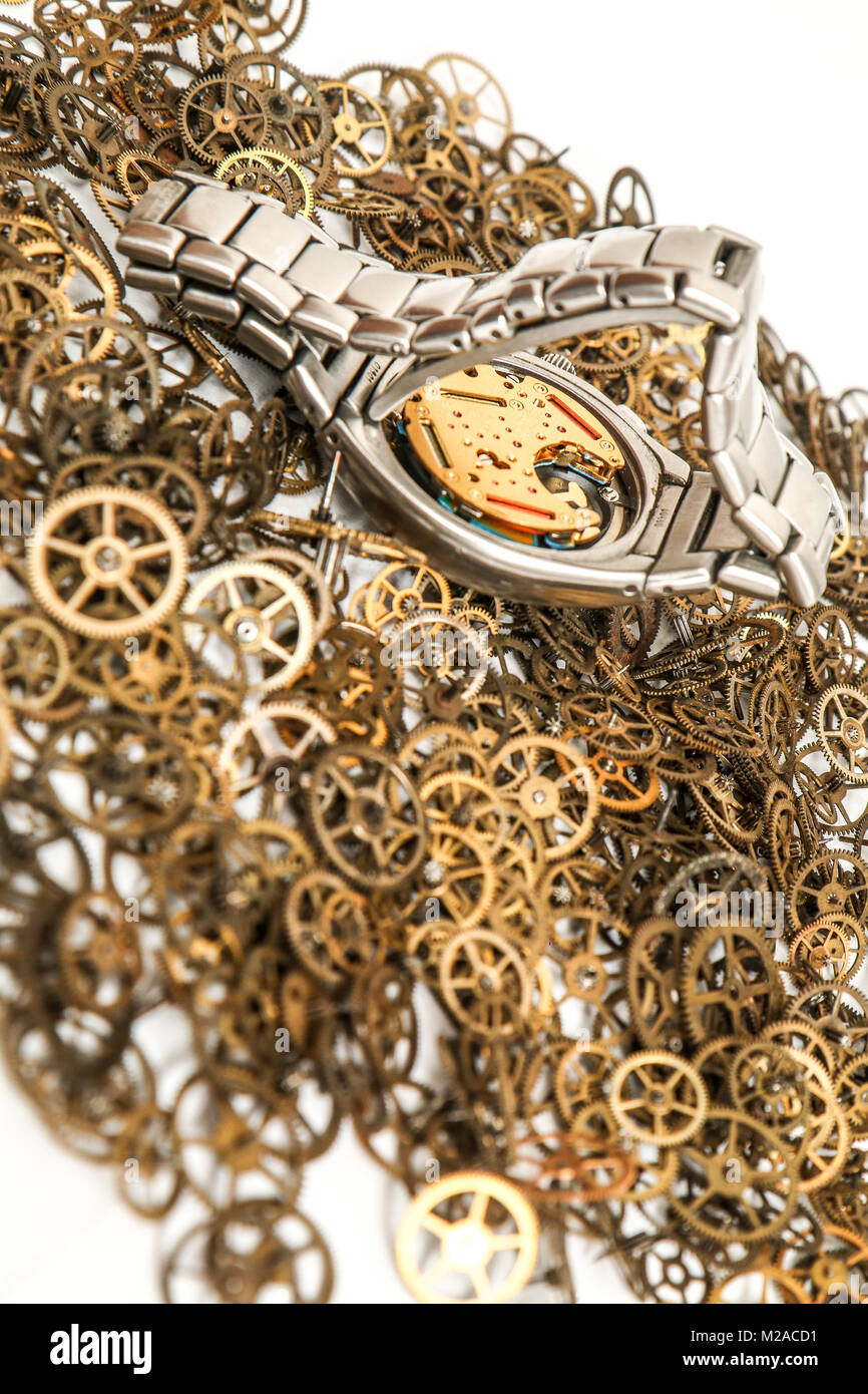 A picture of a small batch of cogwheels with an analog wrist watch on a ...