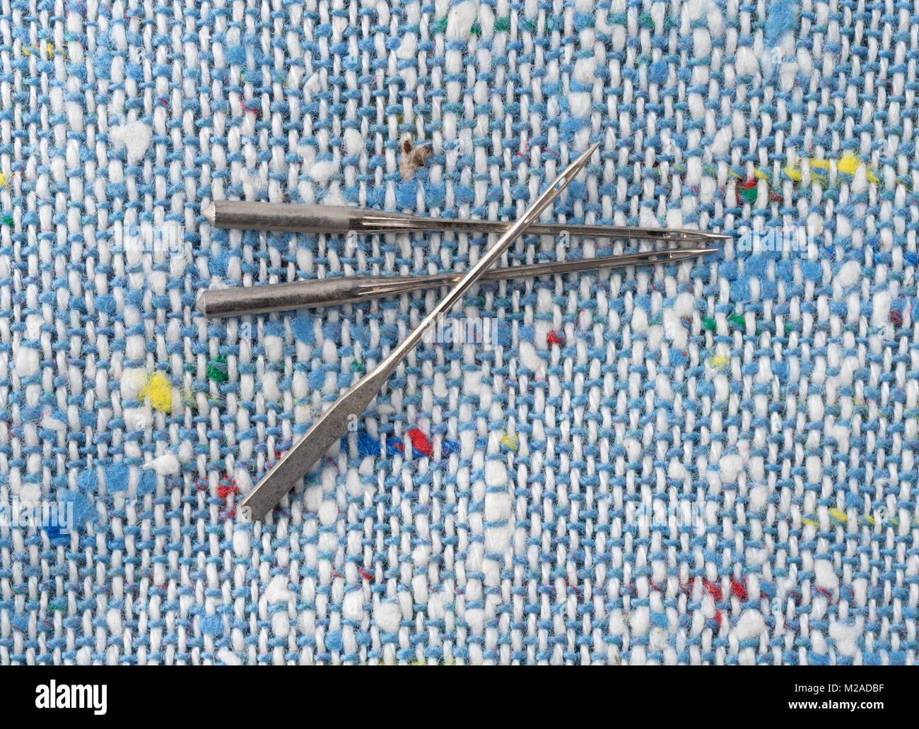 Three sewing machine needles on a colorful cloth Stock Photo - Alamy