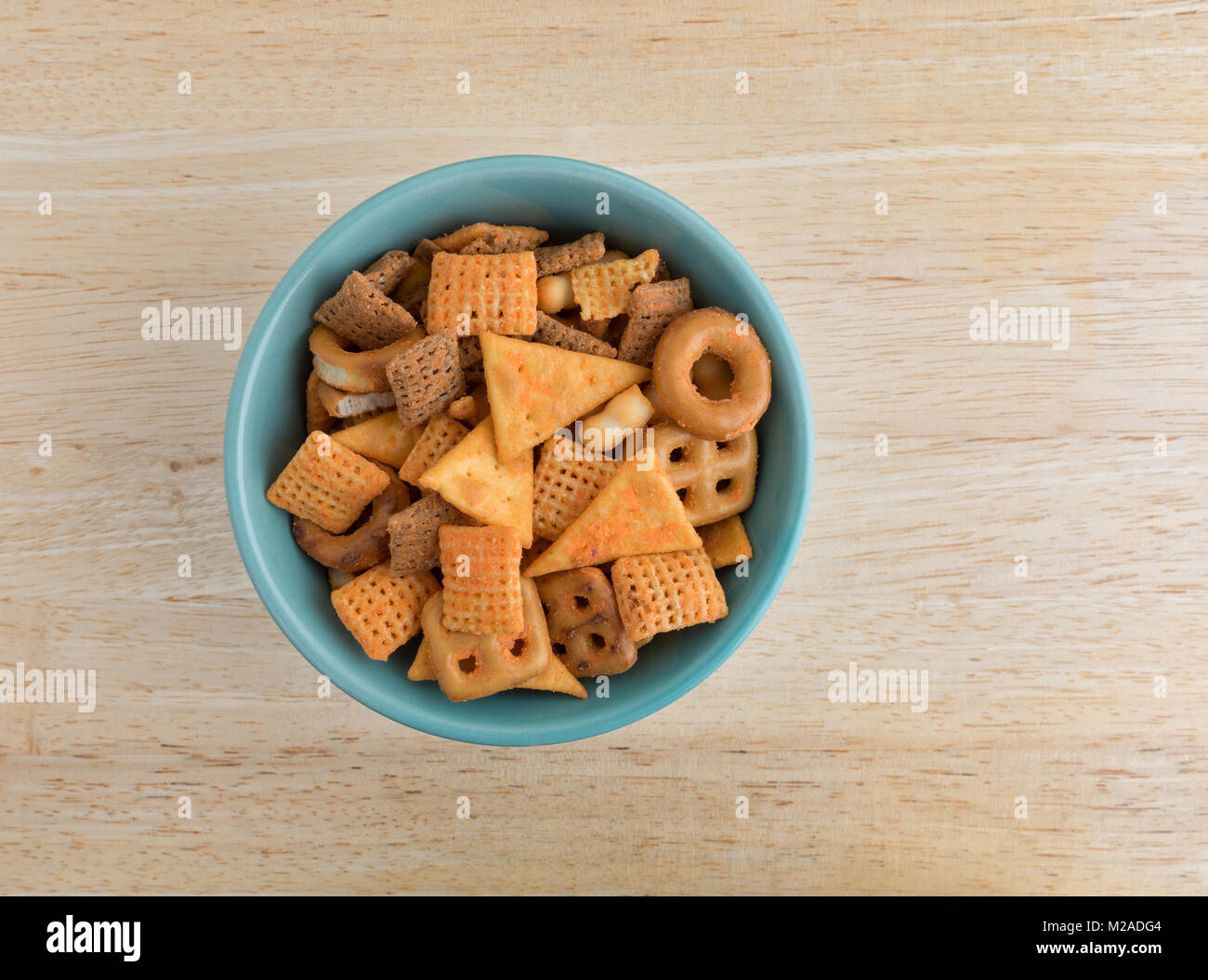 Top view of a mix of small snack food in a bowl on a wood table top ...