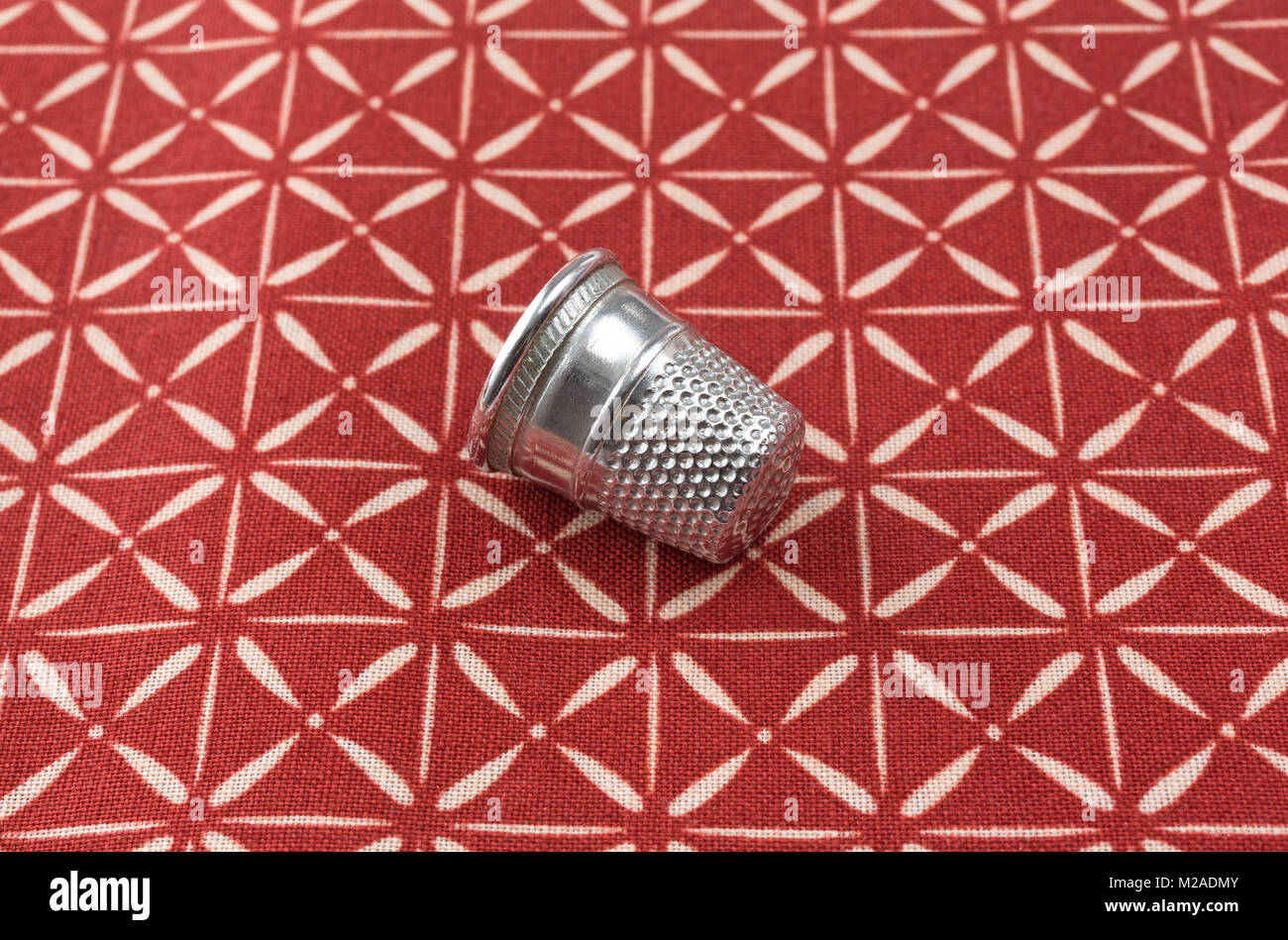 An old metal sewing thimble on a colorful piece of fabric Stock Photo ...
