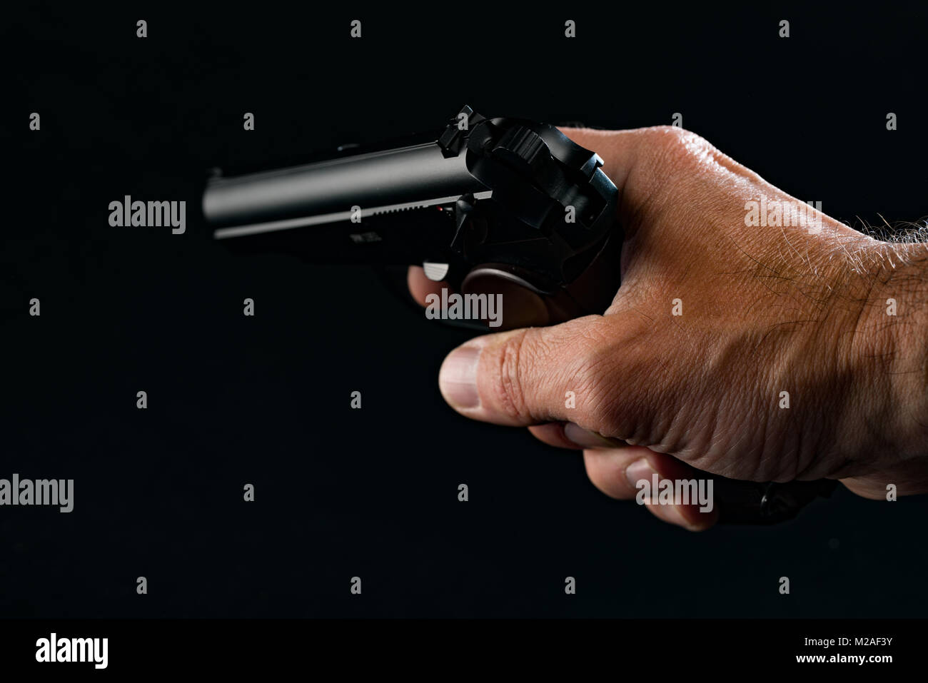 Male hand with gun Stock Photo - Alamy