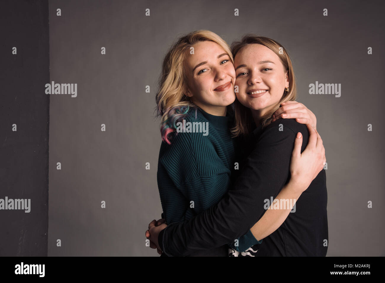 Two young friends standing together. The studio shot Stock Photo - Alamy